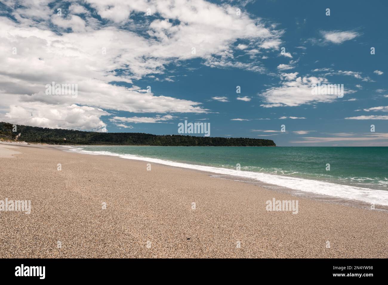 Blue water of the Tasman Sea lapping onto the sand at Maori Beach near ...