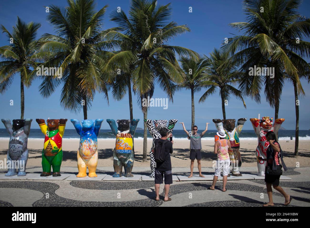 A man poses for photos next to statues that form part of the "United ...