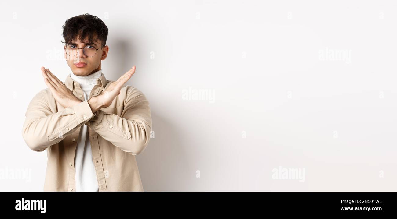 Image of serious young guy in glasses say no, showing cross gesture ...