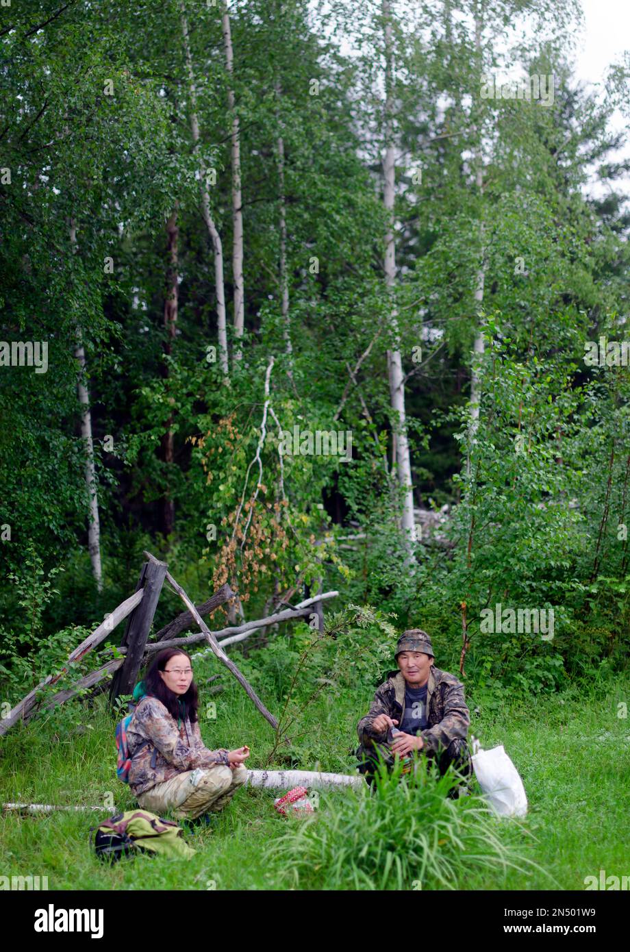 Yakut male old and young Asian girl family sit on vacation eating food ...
