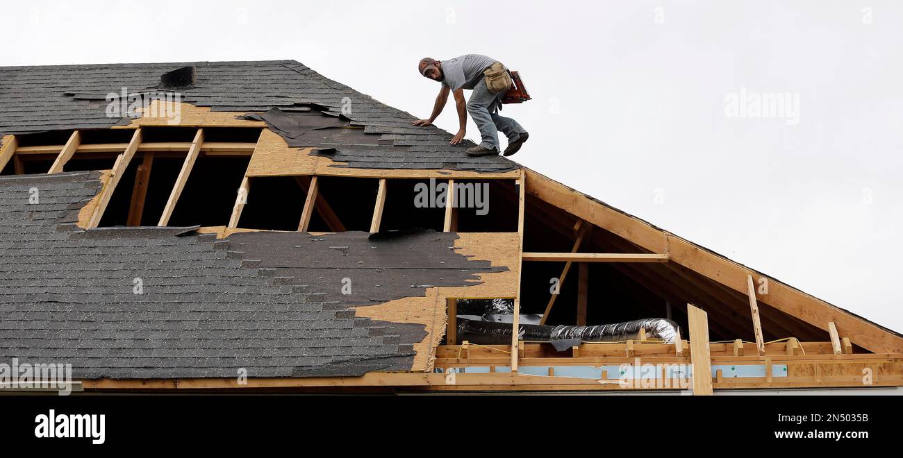 Adam Paxton works on a roof damaged by Sunday's tornado, Tuesday, April ...