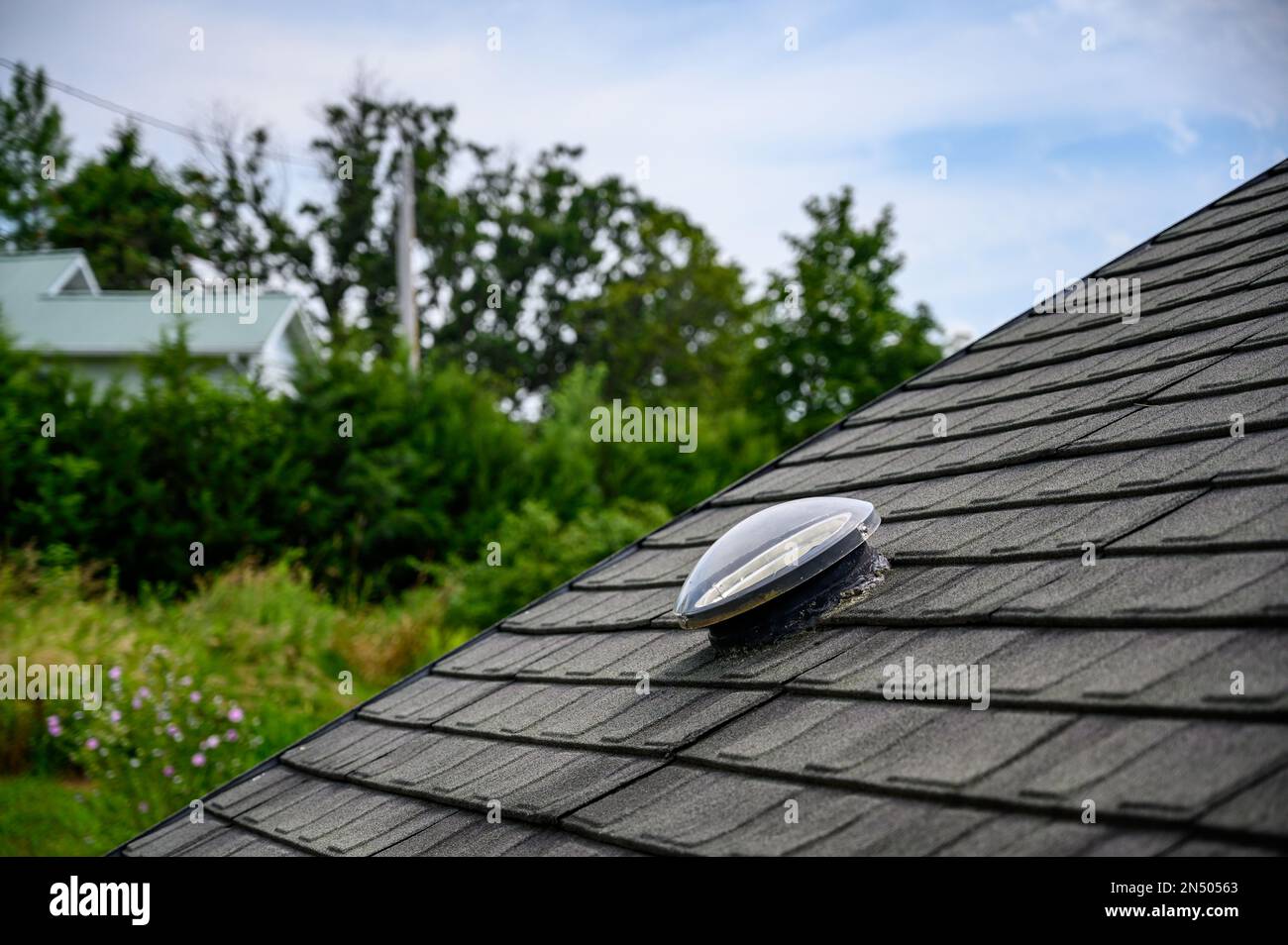 Dome shaped solar tube skylight on asphalt shingle roof Stock Photo - Alamy