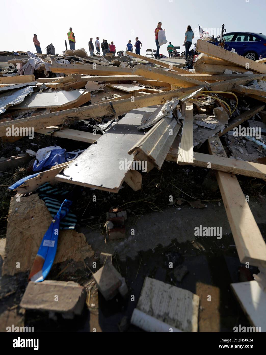 Friends and family sift through debris at the home of Daniel Wassom ...