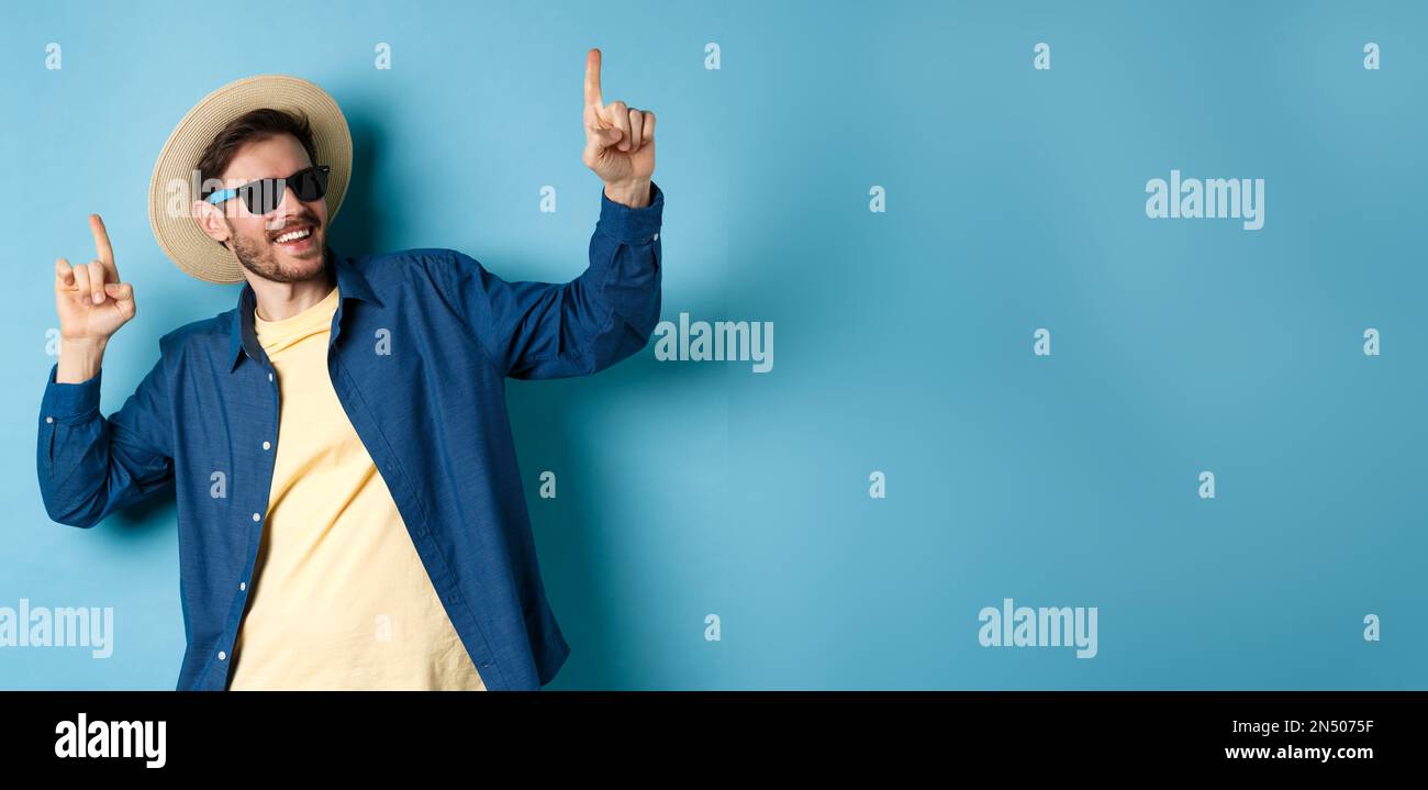 Funny tourist dancing on vacation, pointing fingers up, wearing summer ...