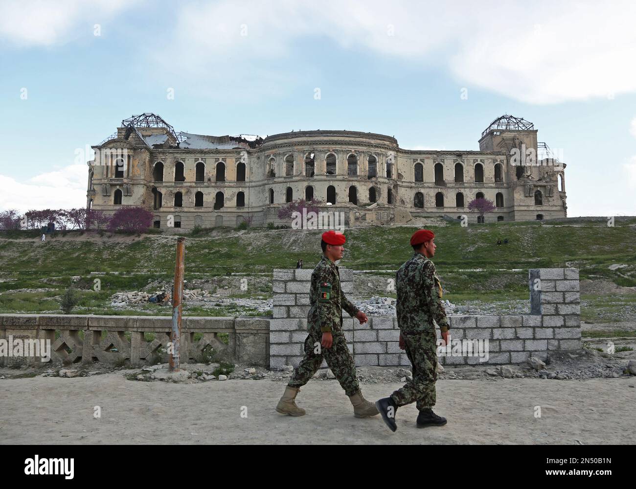 Afghan national army soldiers walk past the palace of the late King ...