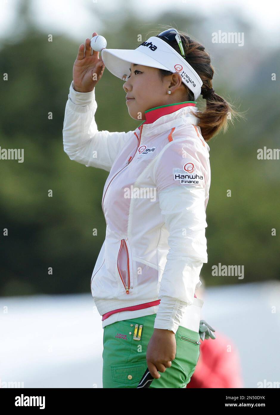 Jenny Shin holds up her ball on the 18th green of the Lake Merced Golf ...