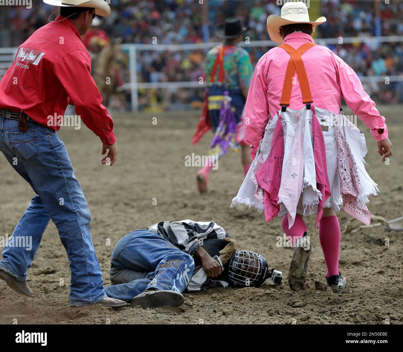 An inmate is assisted after being thrown from a bull at the Angola ...