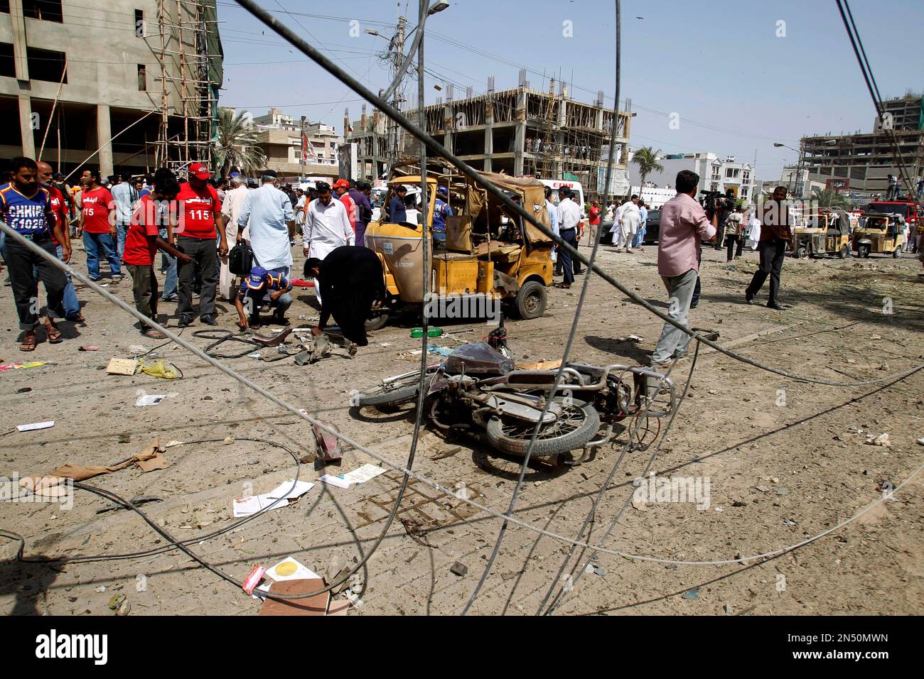 Pakistani officials collect evidence at the site of an explosion in ...