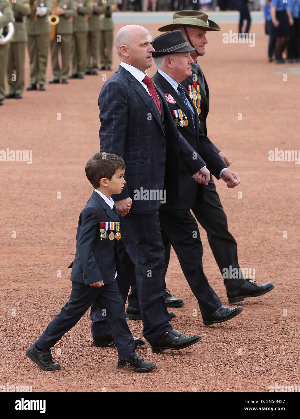 A young boy marches with three men during an Anzac Day parade at the ...