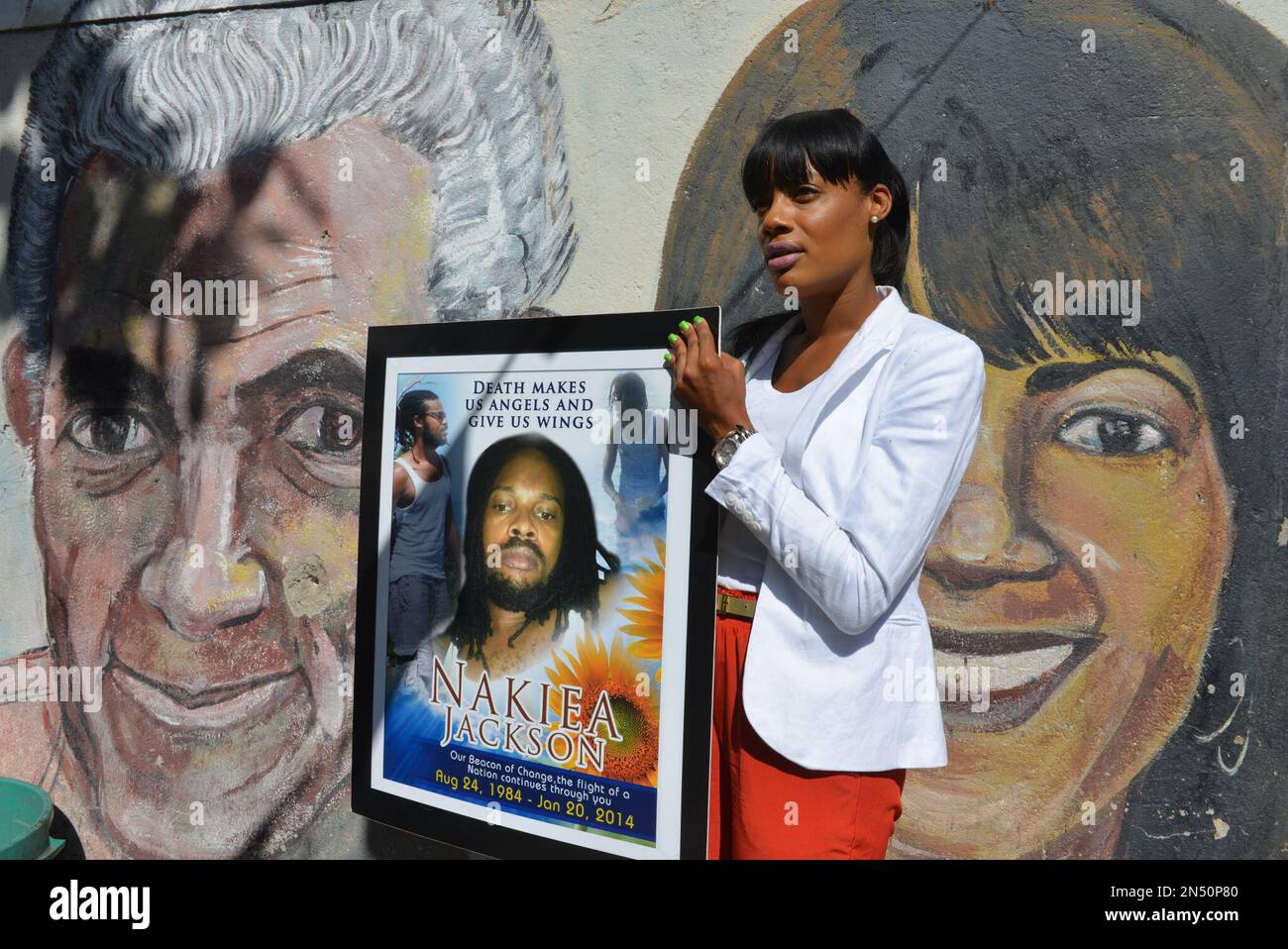 In this April 16, 2014, photo, Shackelia Jackson-Thomas holds a poster ...