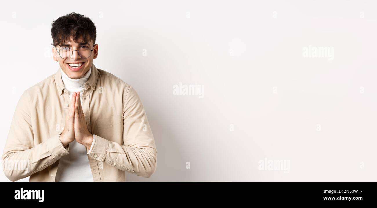 Handsome caucasian man say thank you, bowing with namaste gesture ...