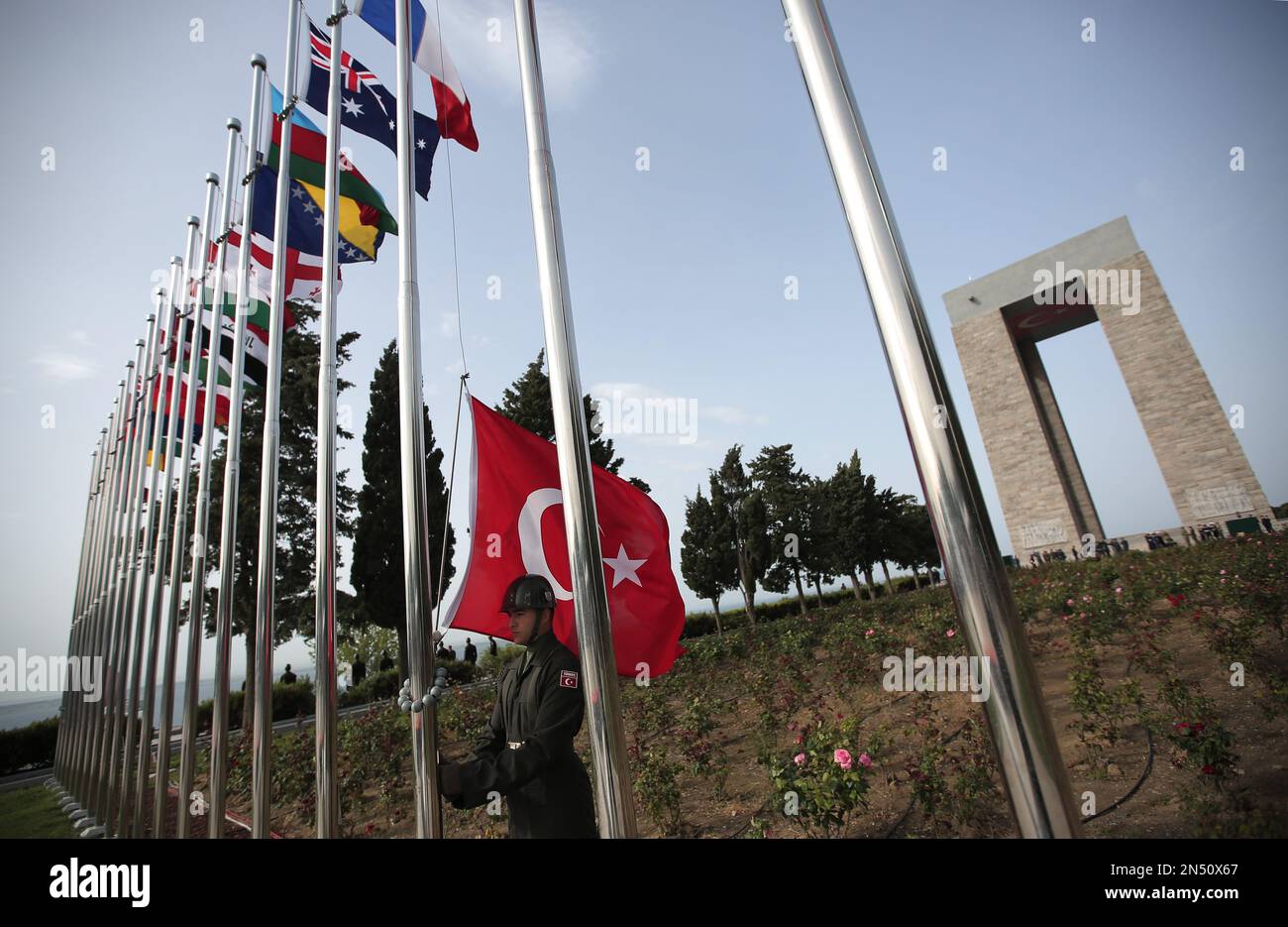 A Turkish soldier hoists his national flag next to other nations flags ...