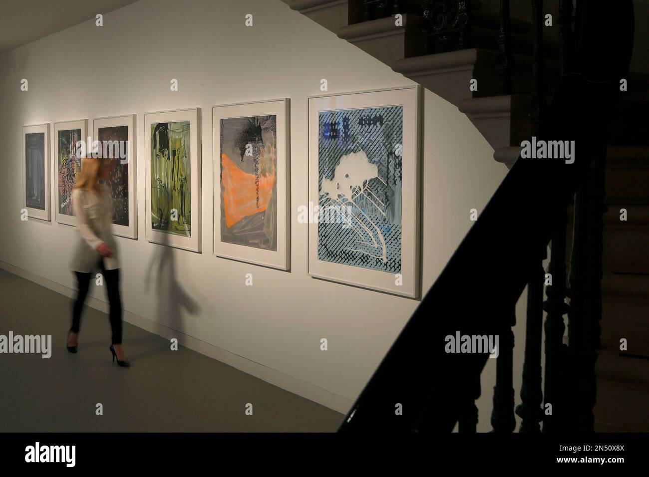A Christie's employee poses with a series of untitled paintings by ...