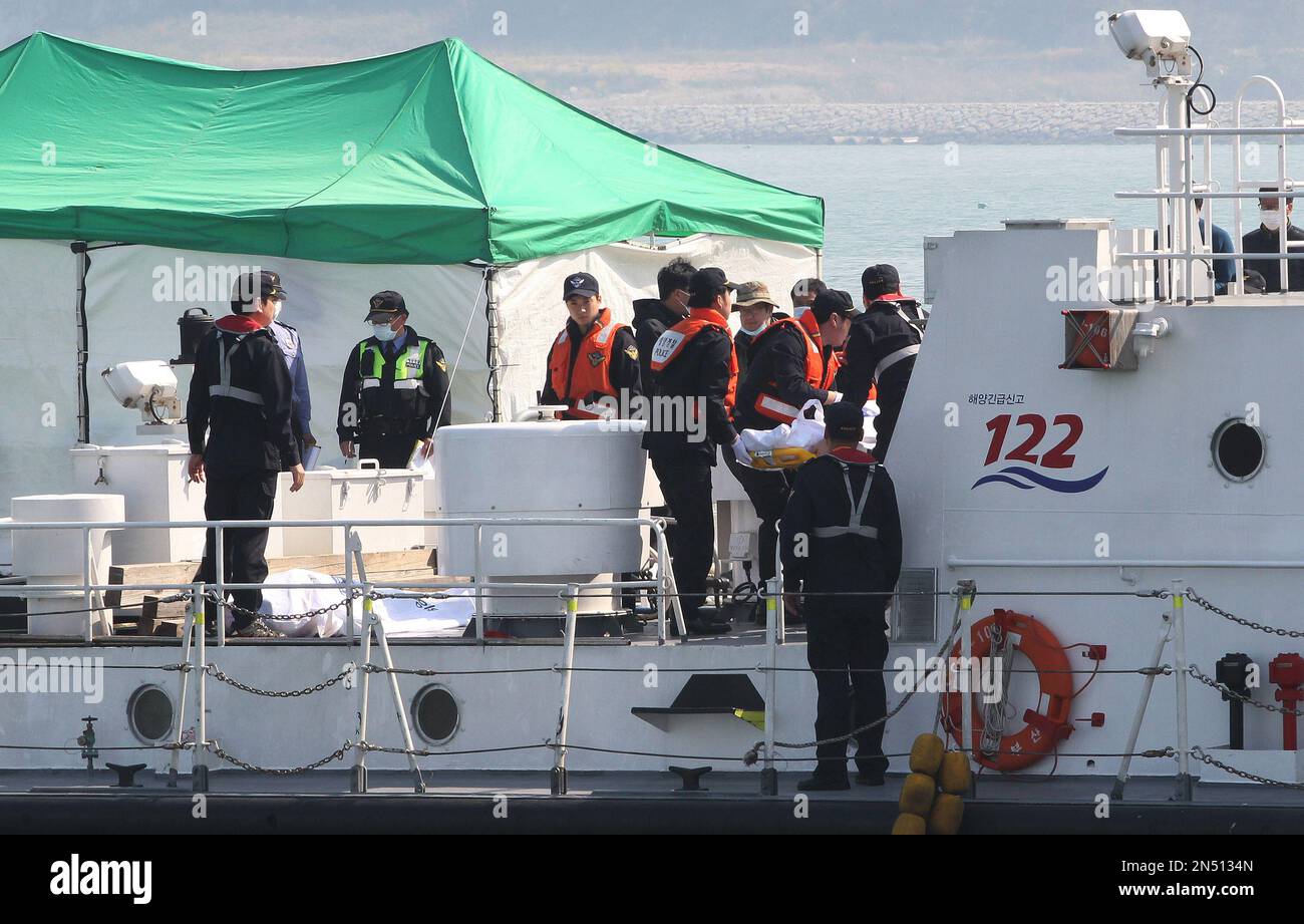 Emergency workers carry the bodies of passengers from the Sewol ferry ...