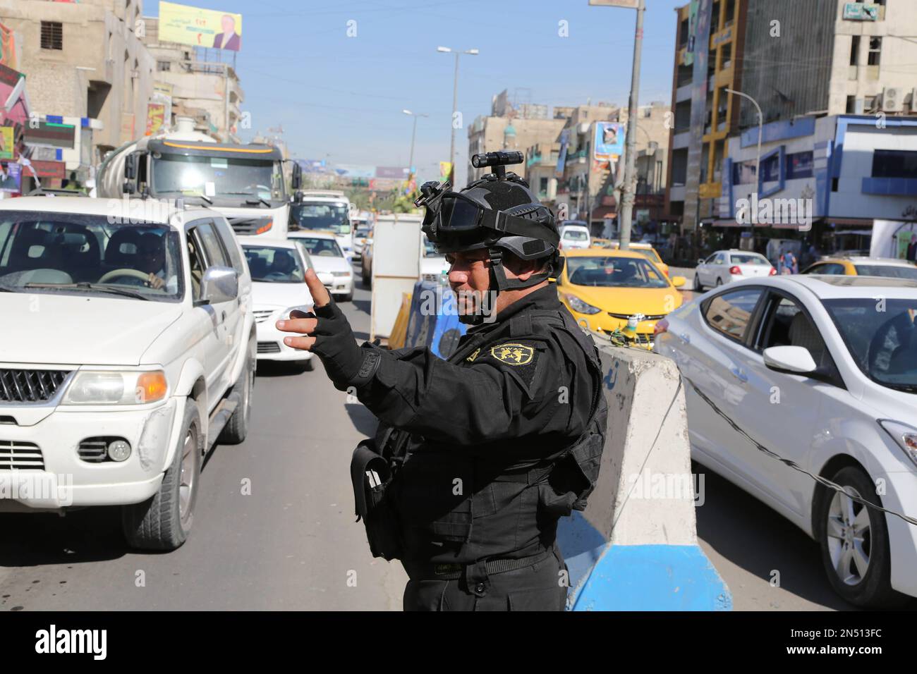 An Iraqi policeman stands guard at a checkpoint in Baghdad, Iraq ...