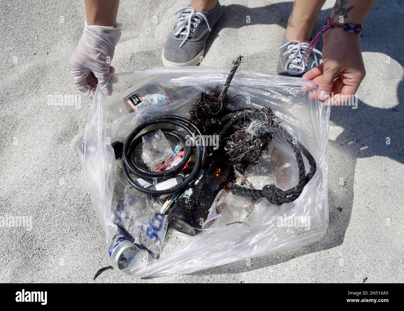 Amanda Digiovanni, 28, of Miami, displays trash she collected on the ...