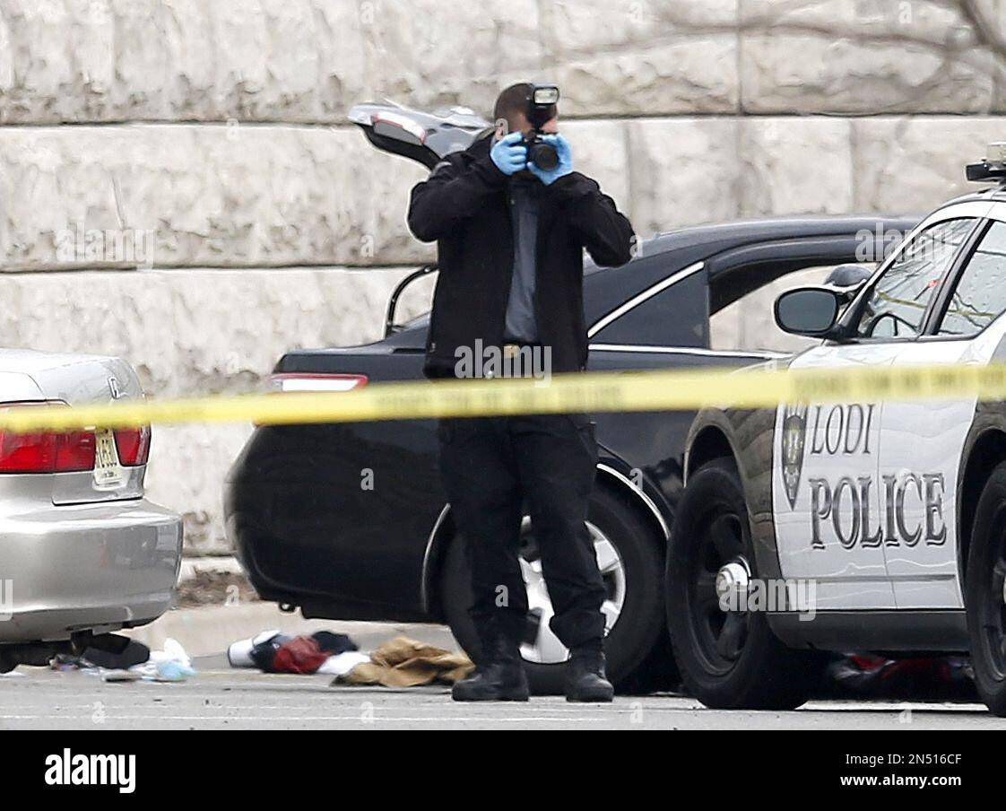 An official takes photographs at the scene where a police officer was ...