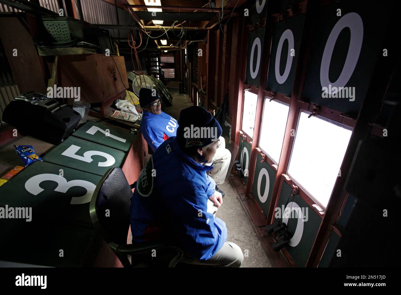 In this April 10, 2014 photo, scoreboard operators Brian Helmus, front ...