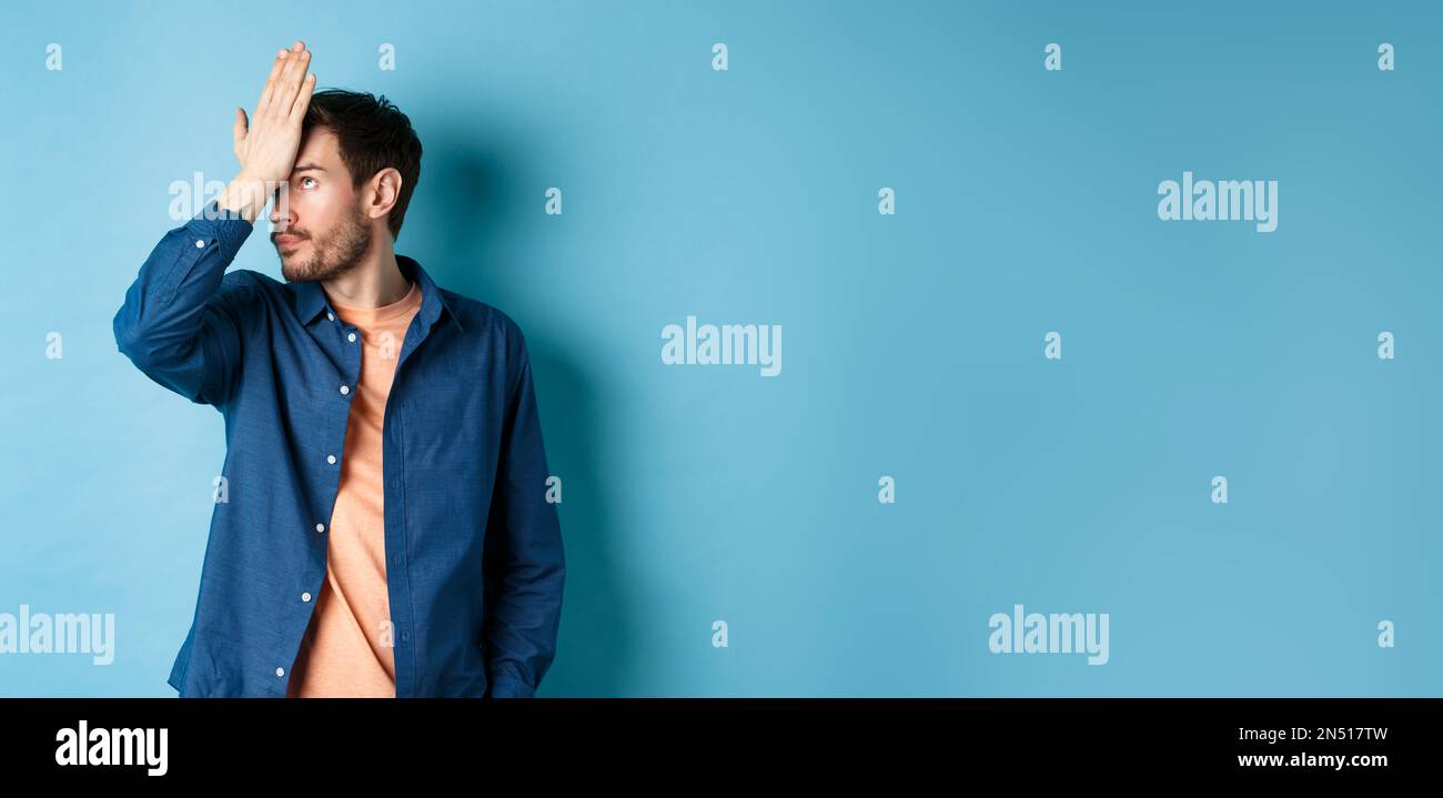 Annoyed and tired man facepalm, roll eyes and look bothered by stupid ...