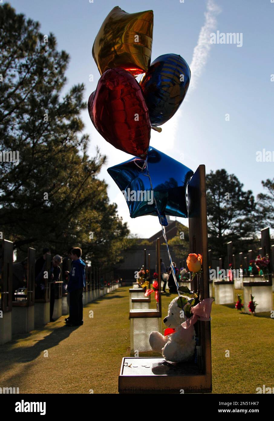 A teddy bear and balloons are silhouetted at the chair of Kevin "Lee ...