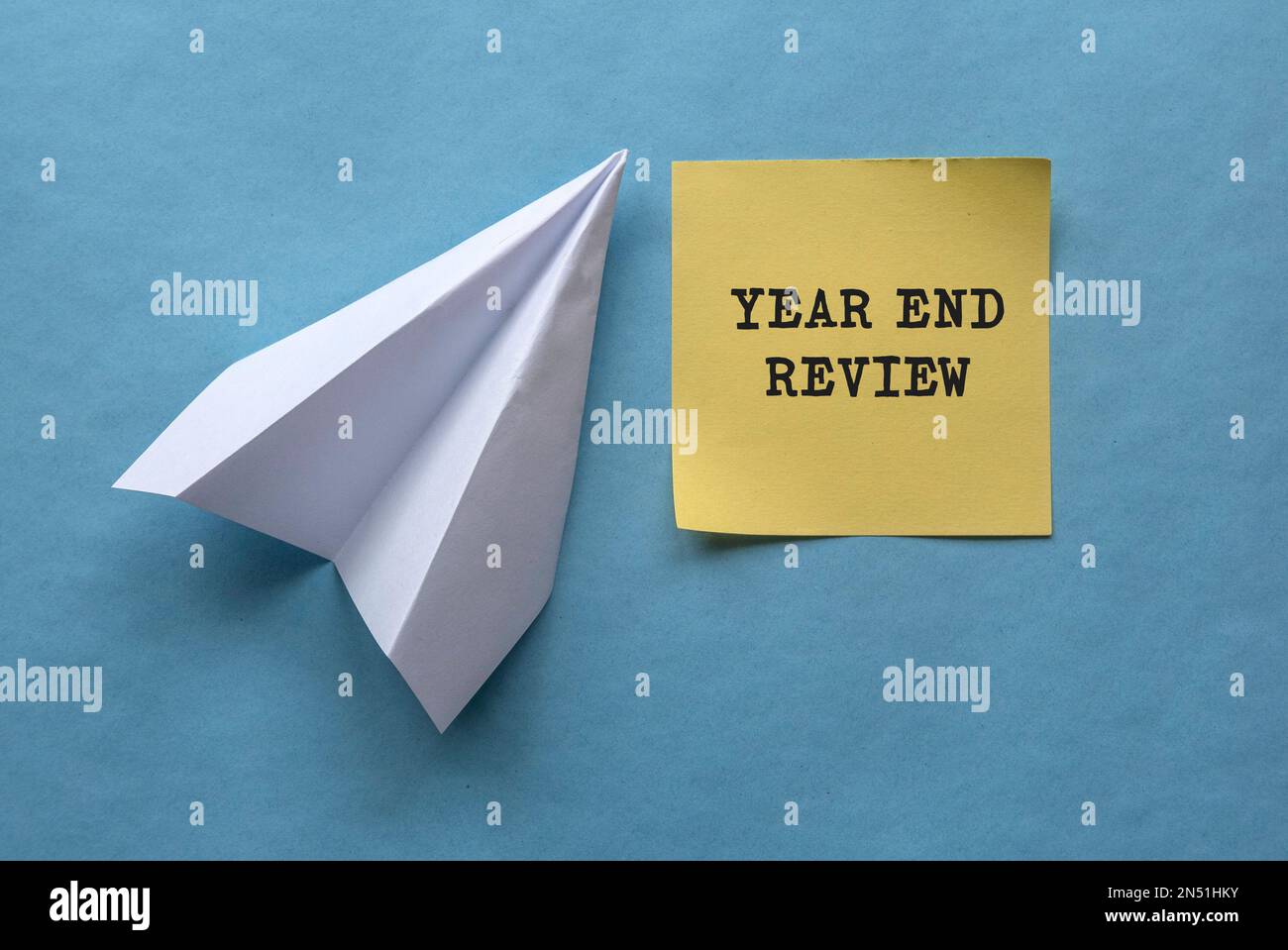 Year end review concept written on yellow memo note with paper plane on ...