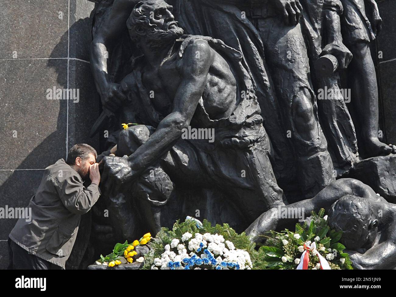 A man prays at the Warsaw Ghetto Heroes Memorial during a ceremony ...