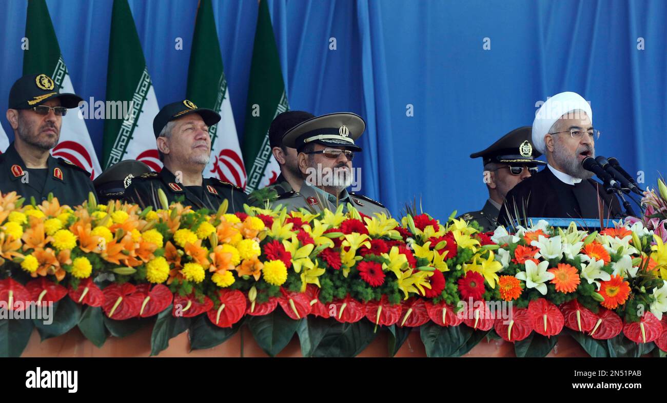 Iranian President Hassan Rouhani, right, speaks in a military parade ...