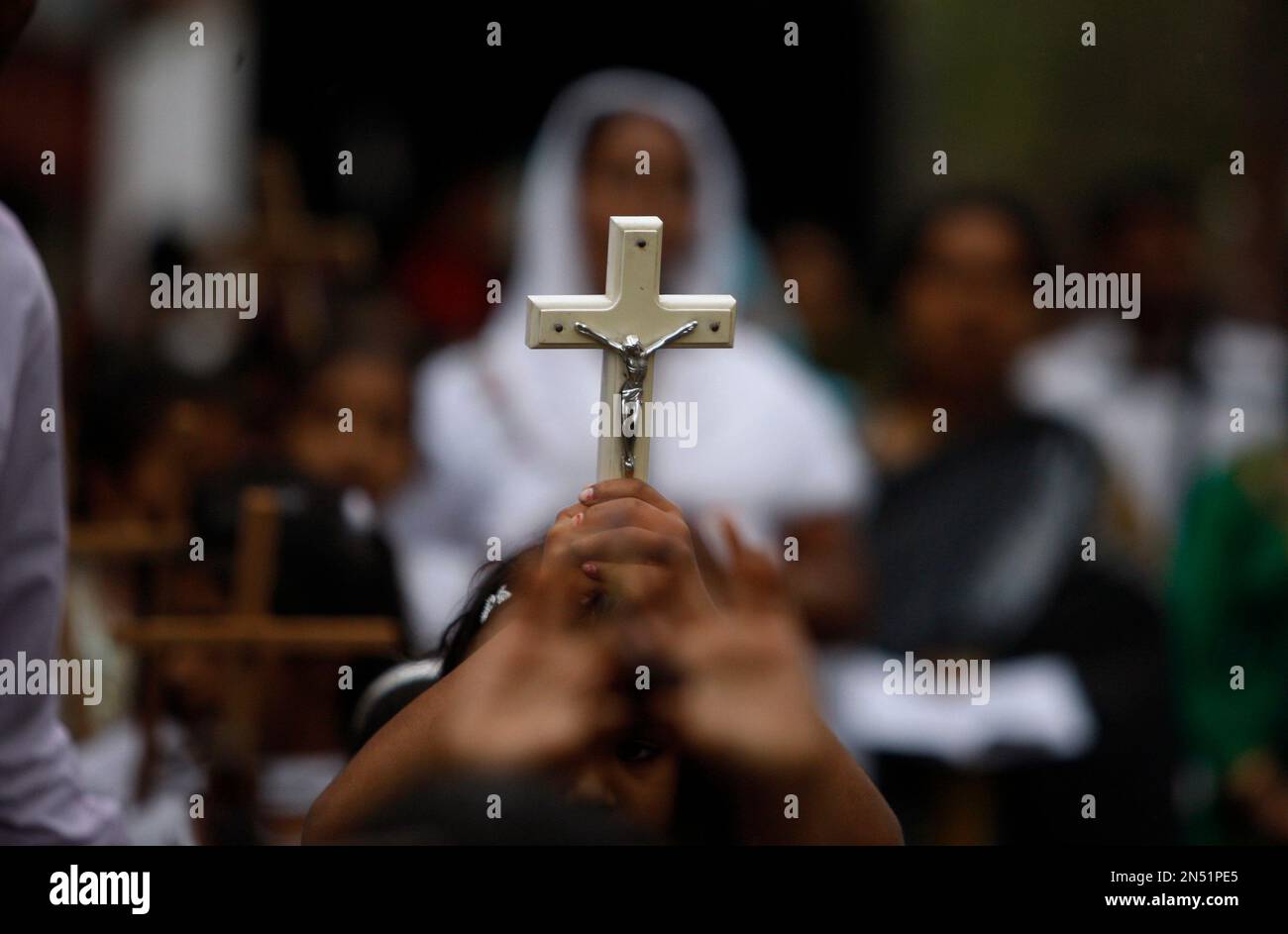 An Indian child holds a crucifix during a procession to mark Good ...