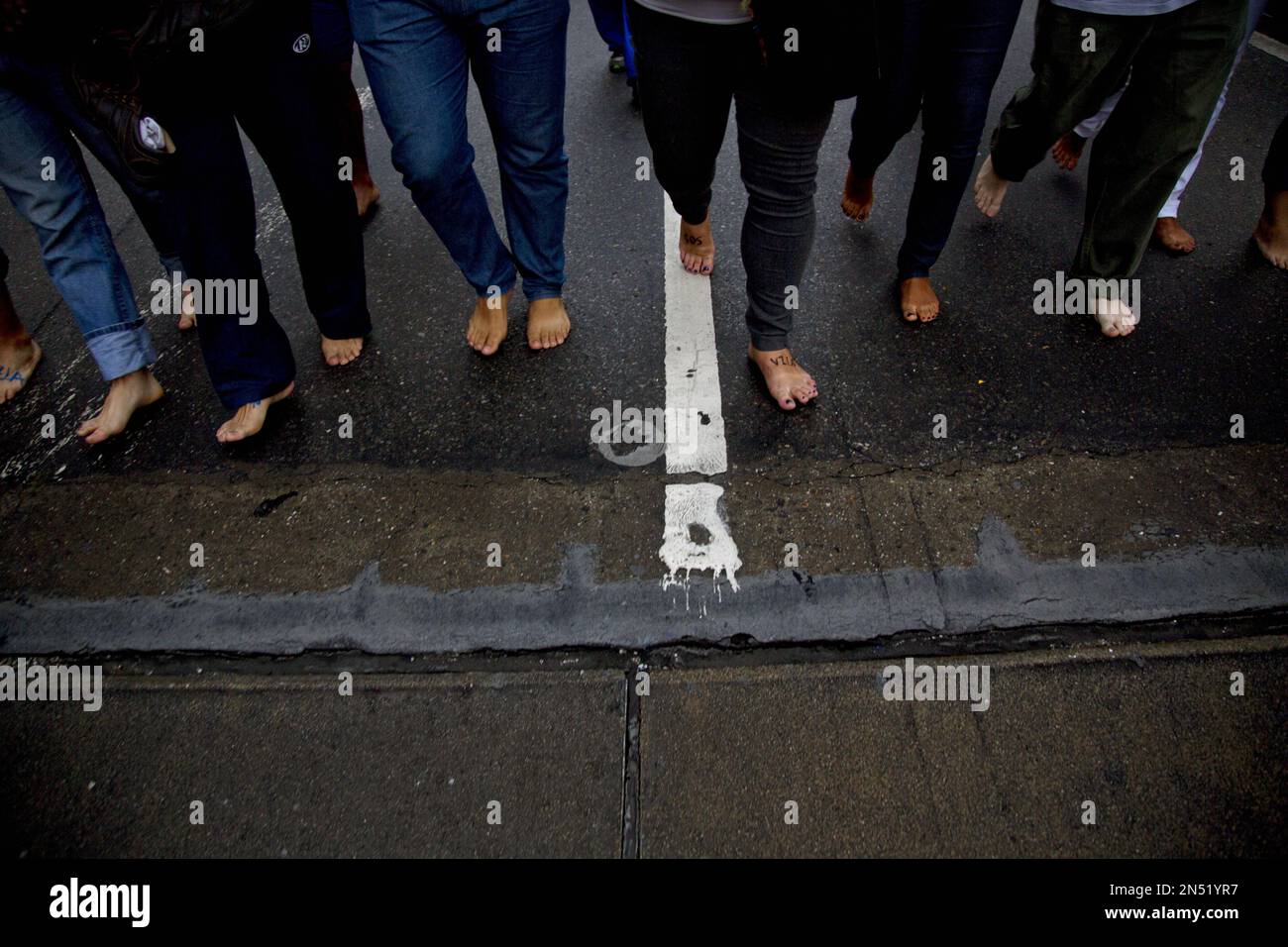 Anti-government protesters march without shoes to a plaza in Caracas ...