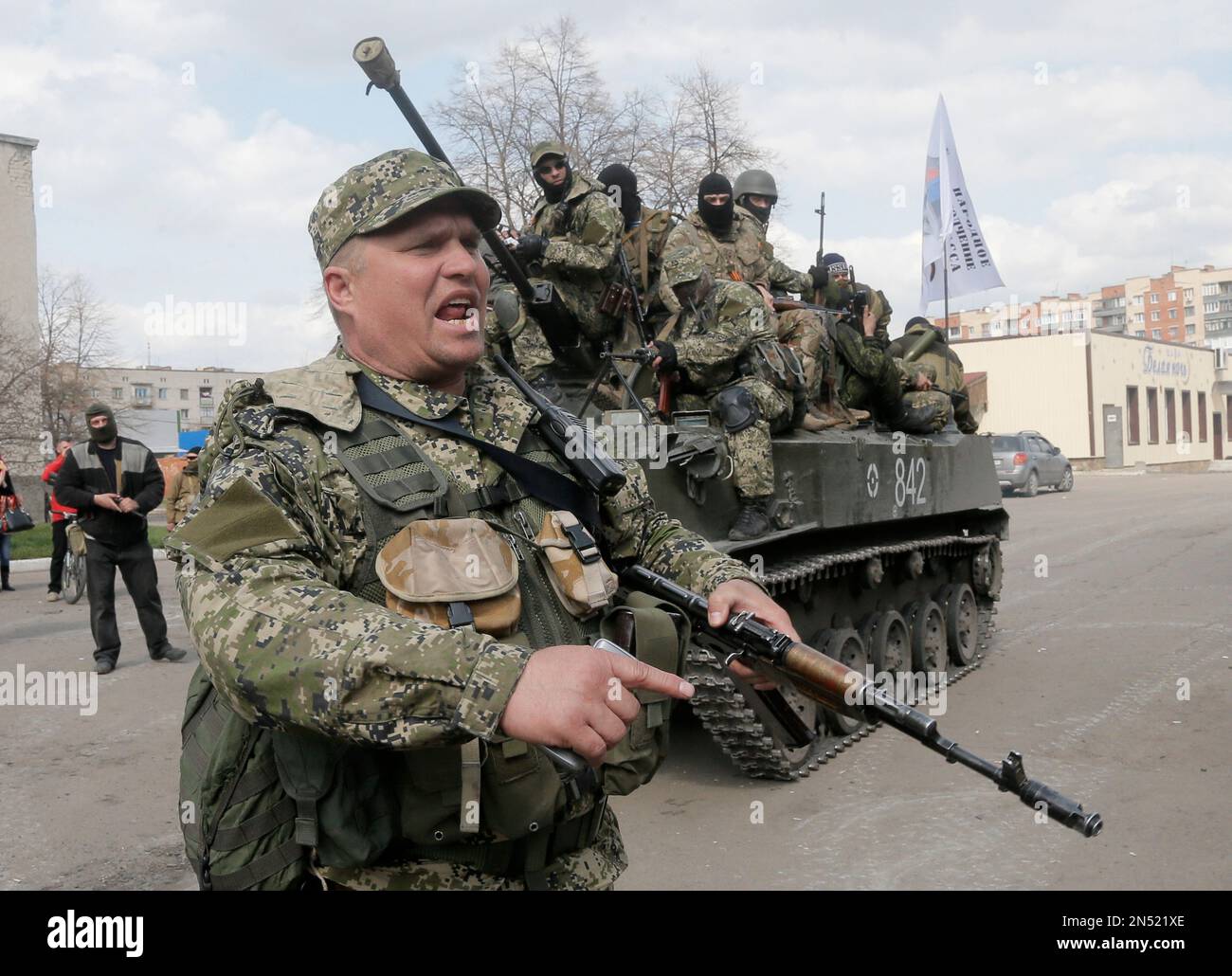 A pro-Russian gunman clears the way for a combat vehicle with gunmen on ...