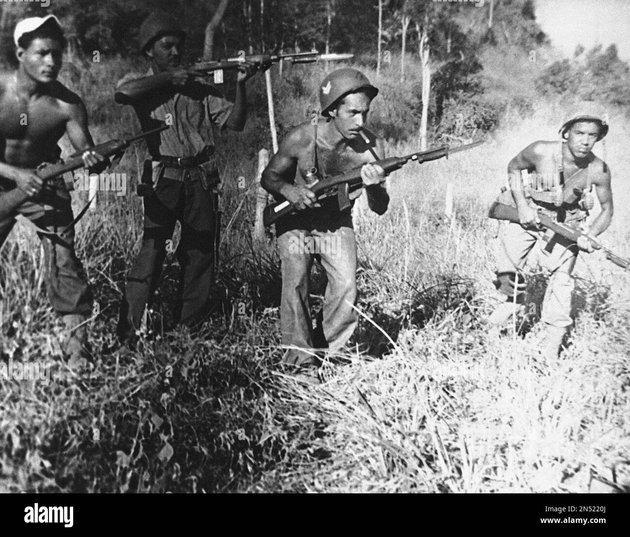 A rebel patrol is shown in action in the mountains near Trinidad, Cuba ...