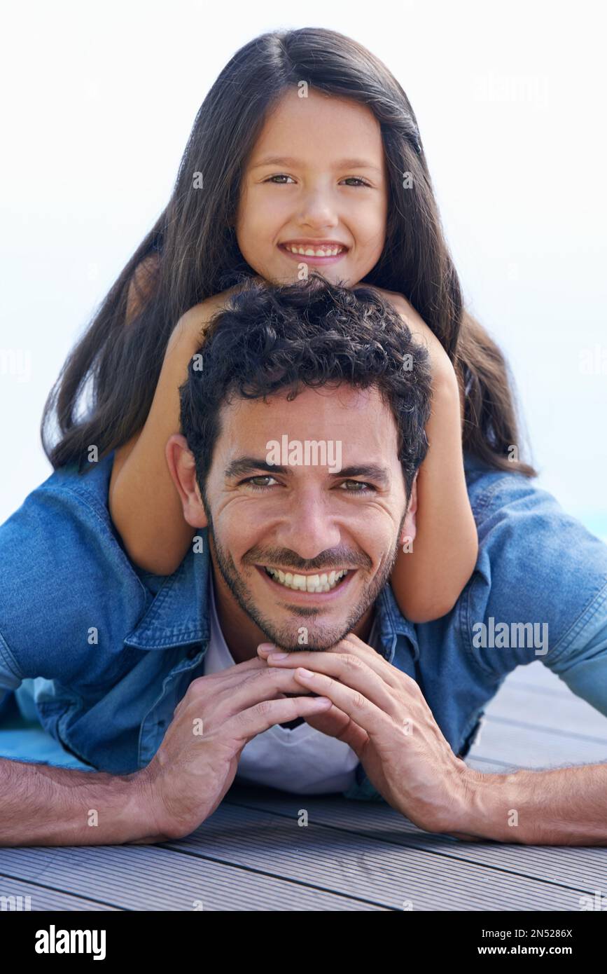 Having a father and daughter moment. Portrait of a little girl laying ...