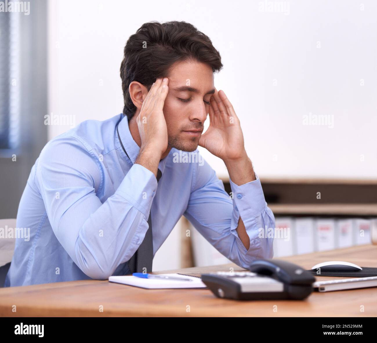 Work is just too much. A young businessman looking tired and frustrated ...