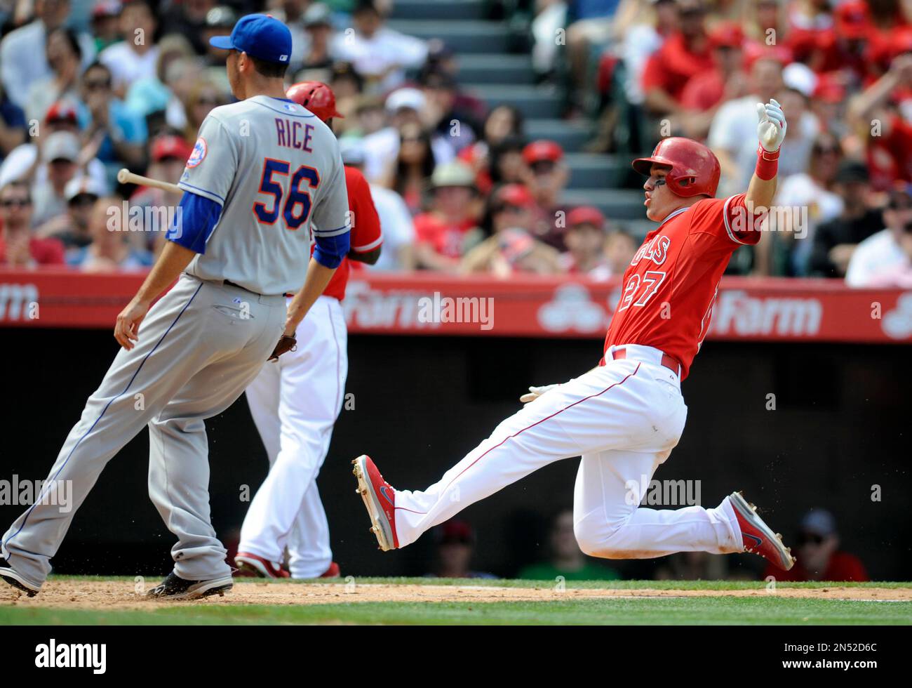 Los Angeles Angels' Mike Trout, right, slides into home on a wild pitch ...