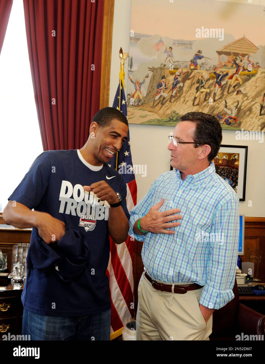 Connecticut coach Kevin Ollie, left, talks with Connecticut Gov. Dannel ...