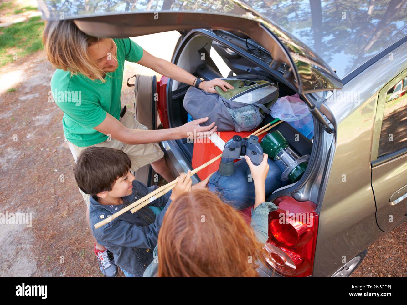 I think weve got everything we need. a happy family packing the trunk ...
