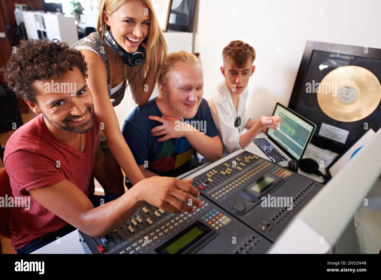 Creating a hit takes time...Four young audio engineers working on a ...
