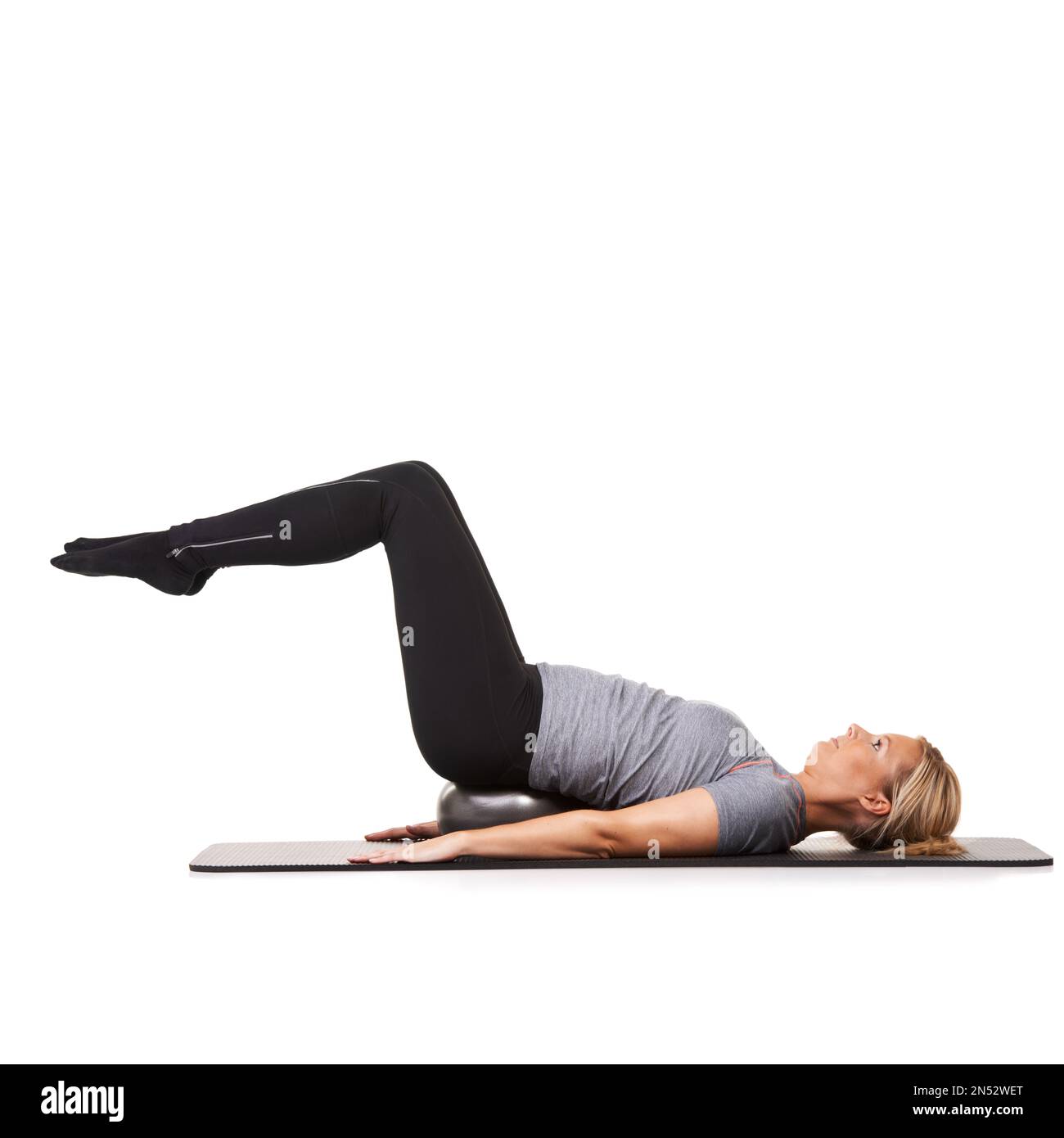 Holding the position. A young woman performing leg exercises while ...