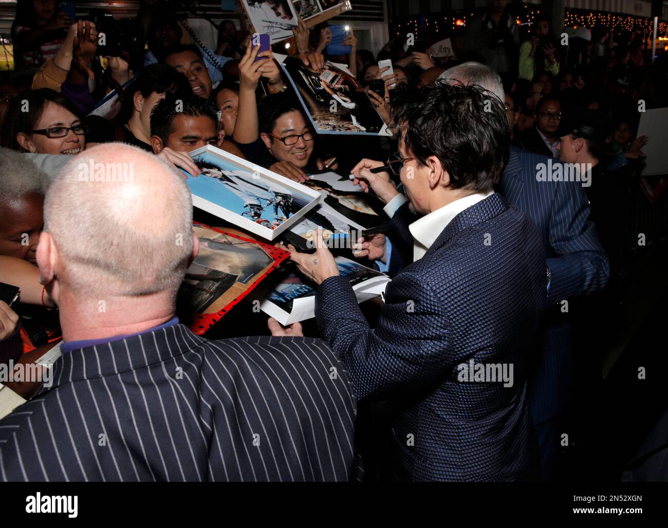 Johnny Depp signs autographs as he arrives at the Los Angeles premiere ...