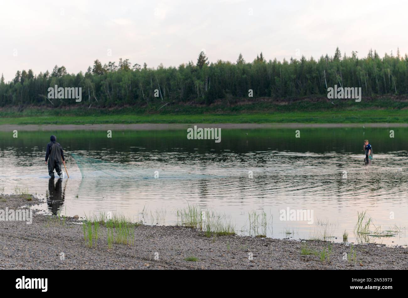 Two men of the Yakuts in the background gulls are in wading boots with ...