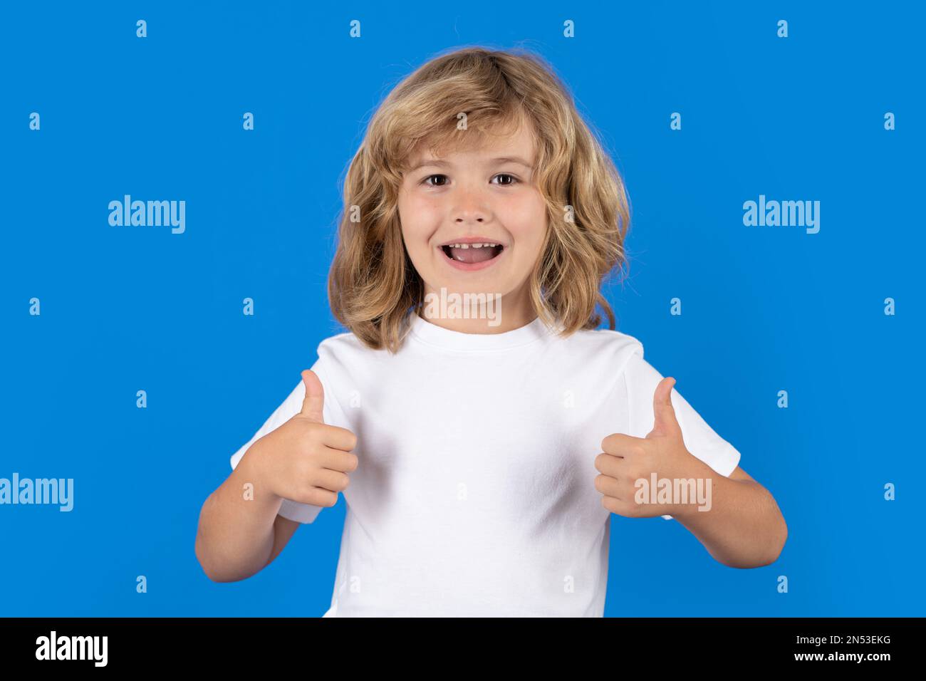 Excited kid boy with thumbs up on studio isolated background. Surprised ...