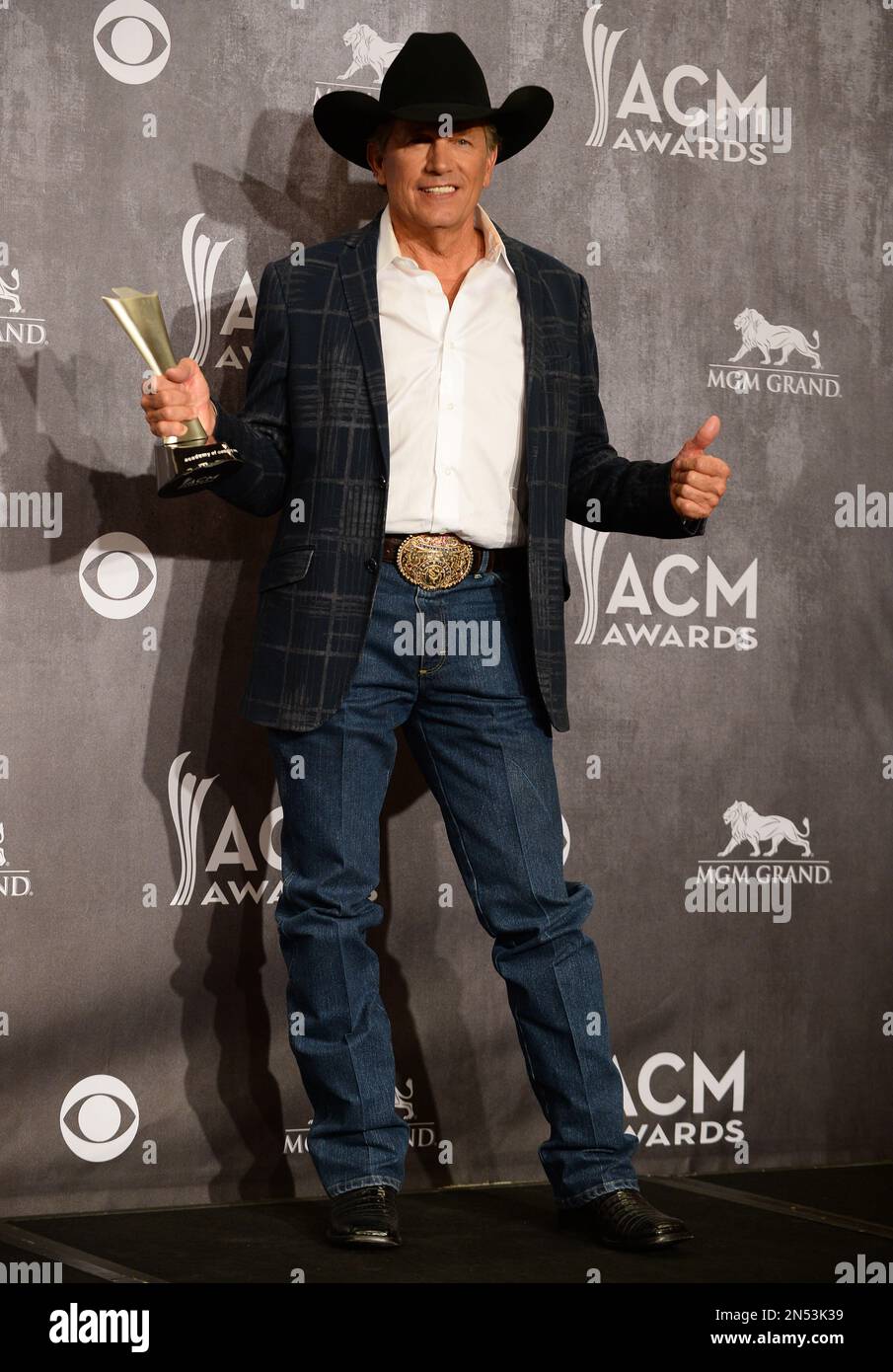 George Strait poses in the press room with the award for entertainer of ...