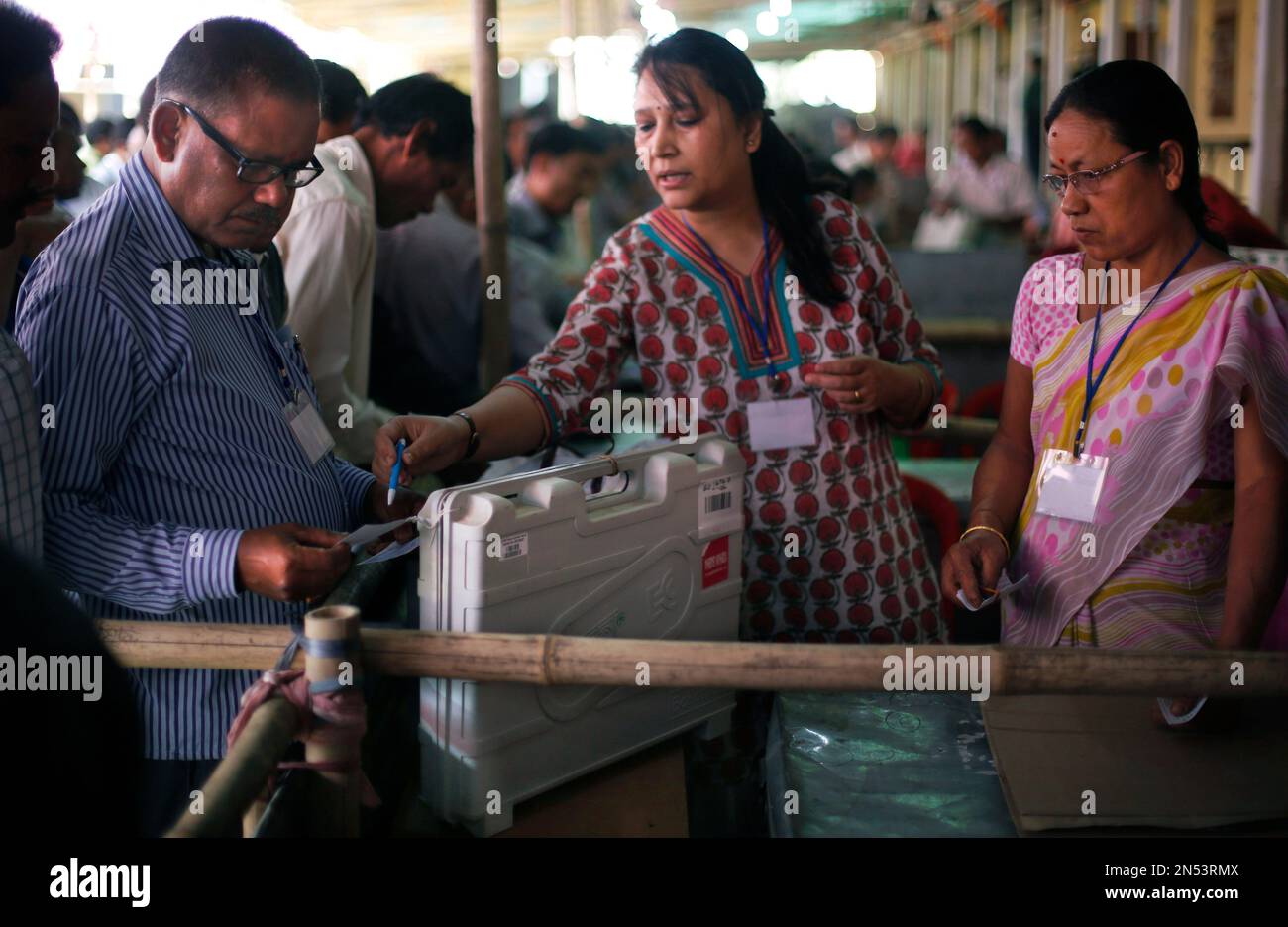 An Indian election official, left, receives an electronic voting ...
