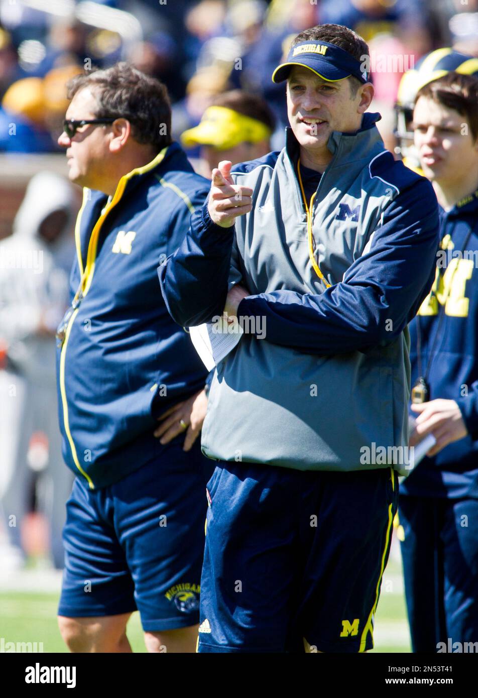 Michigan offensive coordinator Doug Nussmeier, front, stands next to ...