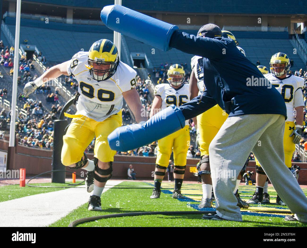 Michigan defensive tackle Matthew Godin (99) runs around a blocking ...