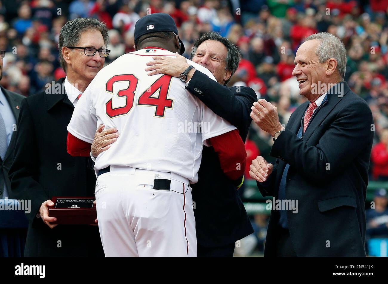 Boston Red Sox's David Ortiz (34) hugs Tom Werner as John Henry, left ...