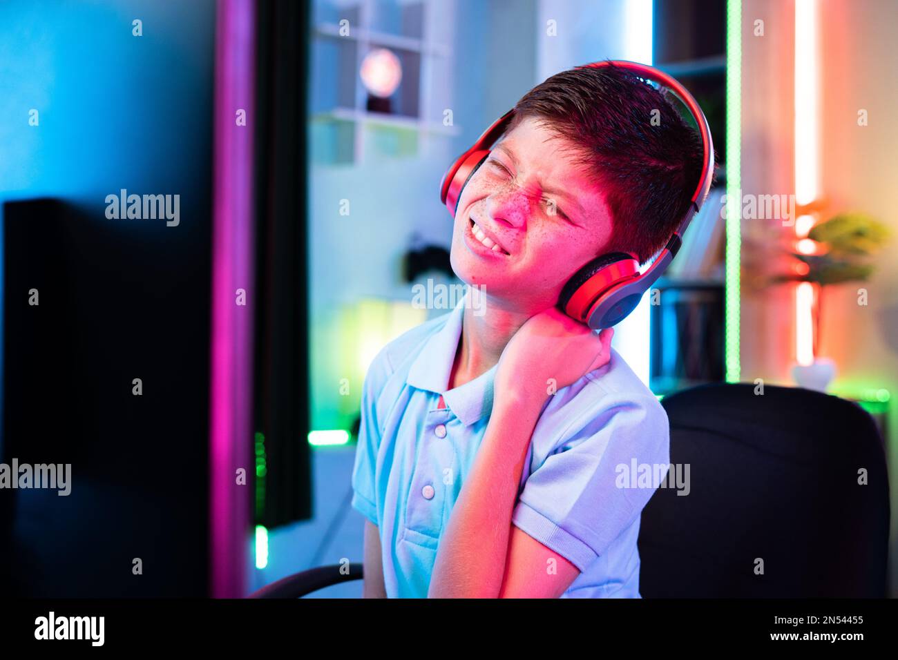 exhausted teenager kid suffering from neck pain due to over playing of ...