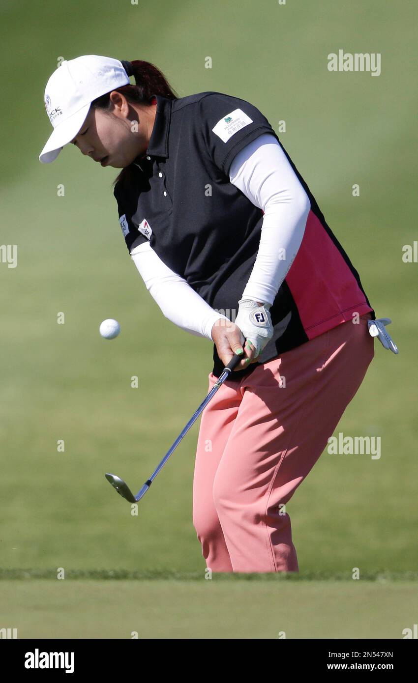 Shanshan Feng, of China, chips to the green on the ninth hole during ...