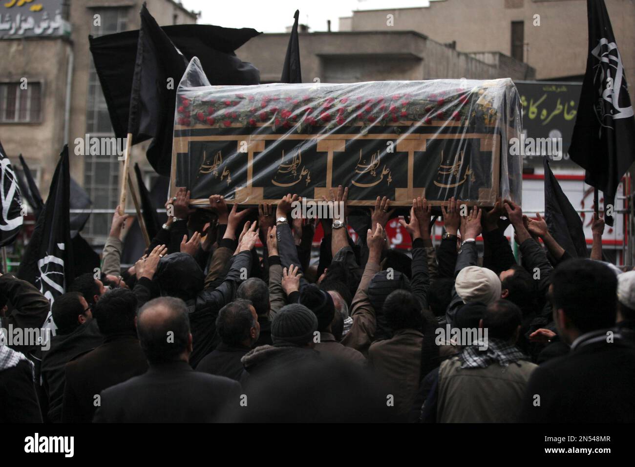 Iranian Shiite mourners carry a symbolic coffin of Fatima, the daughter ...