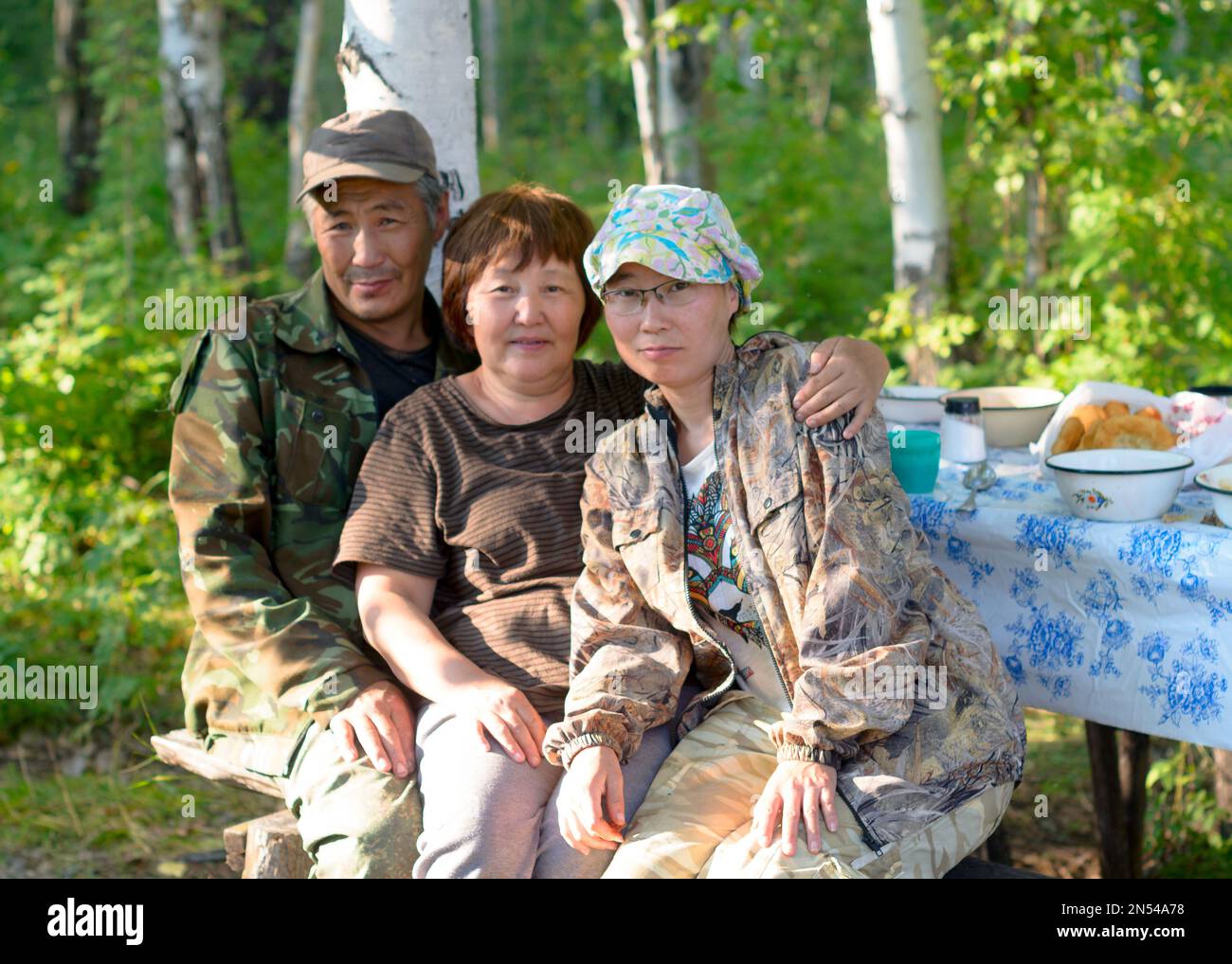 An elderly couple of rural Asian Yakuts and a young girl family pose on ...